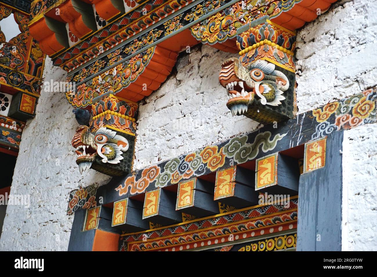 Carved and painted woodwork on a historic stone building at Punakha ...