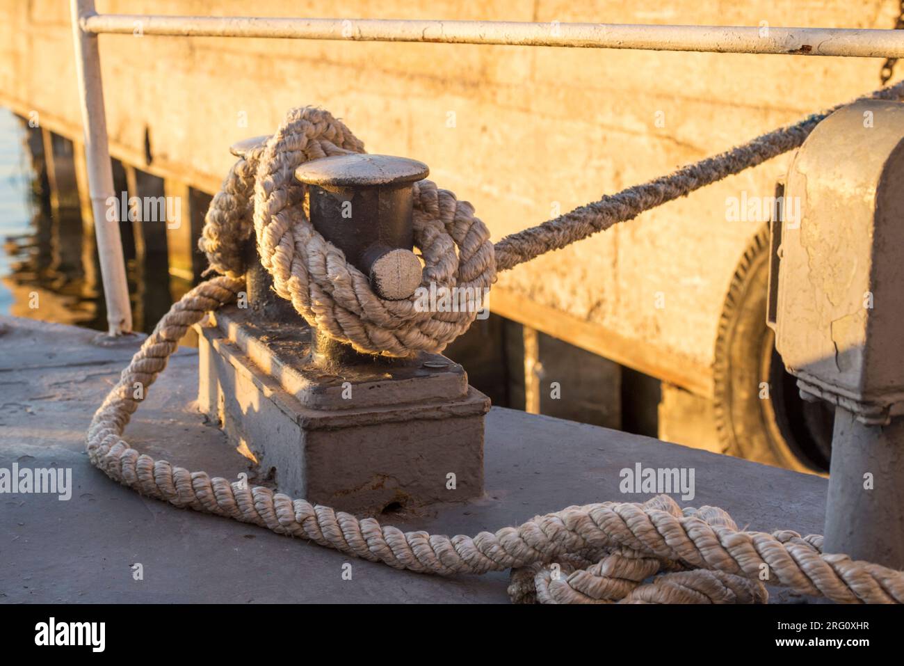 Tied rope knot on metallic bollard seafaring port. Nautical ship moored ...