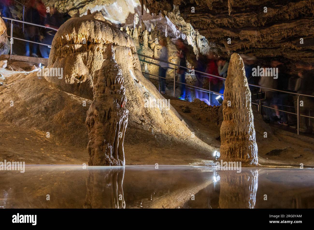Tourists visiting an underground pond with stalagmites in Belianska ...