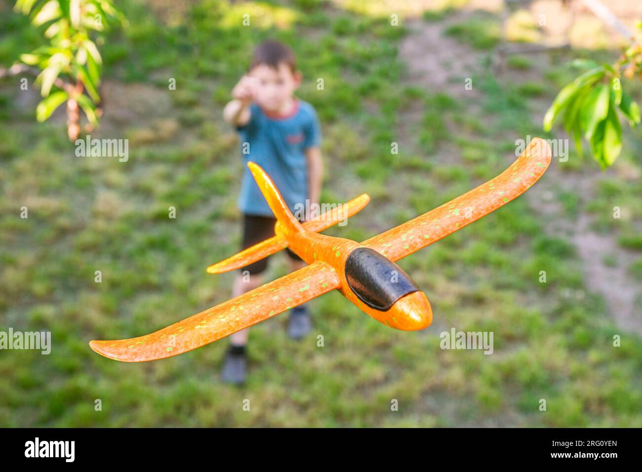 Little boy launches a toy plane into the air. Child launches a toy ...