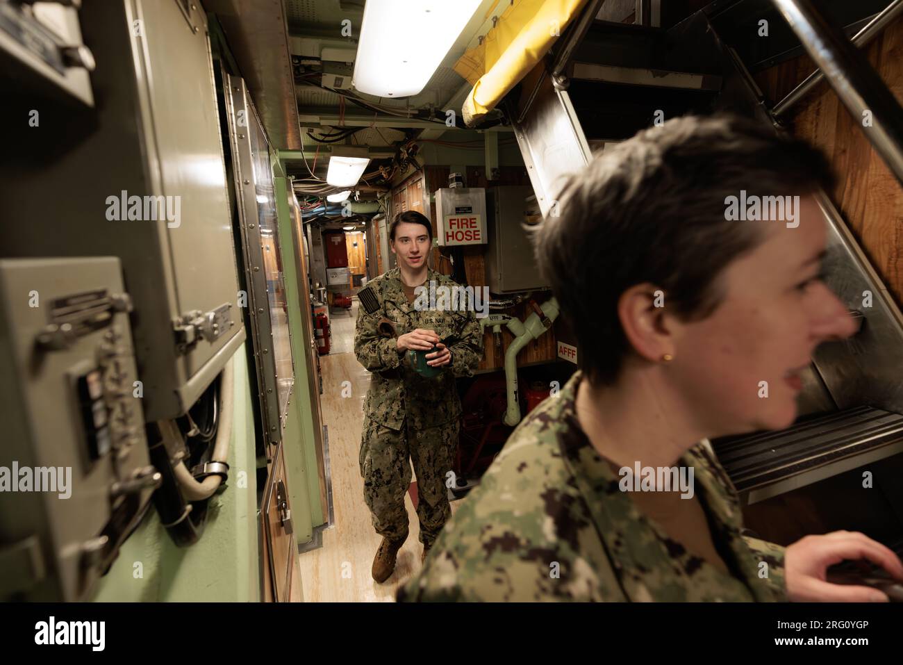 Crew members are seen in the narrow walkways onboard the USS North ...