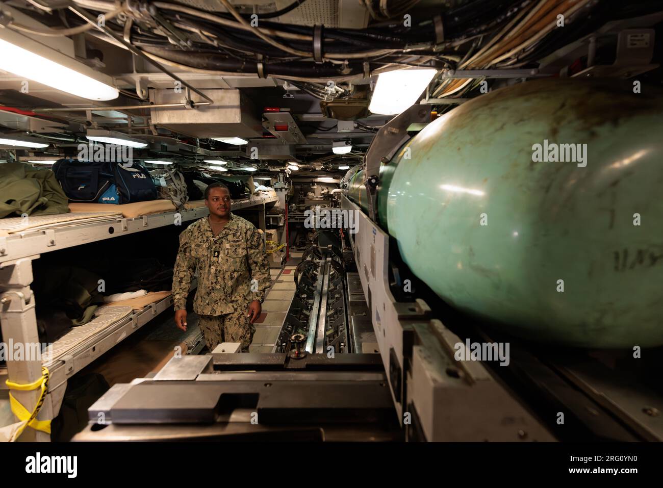 A crew member is seen walking between crew bunk areas (left) and an Advanced Capability (ADCAP ...