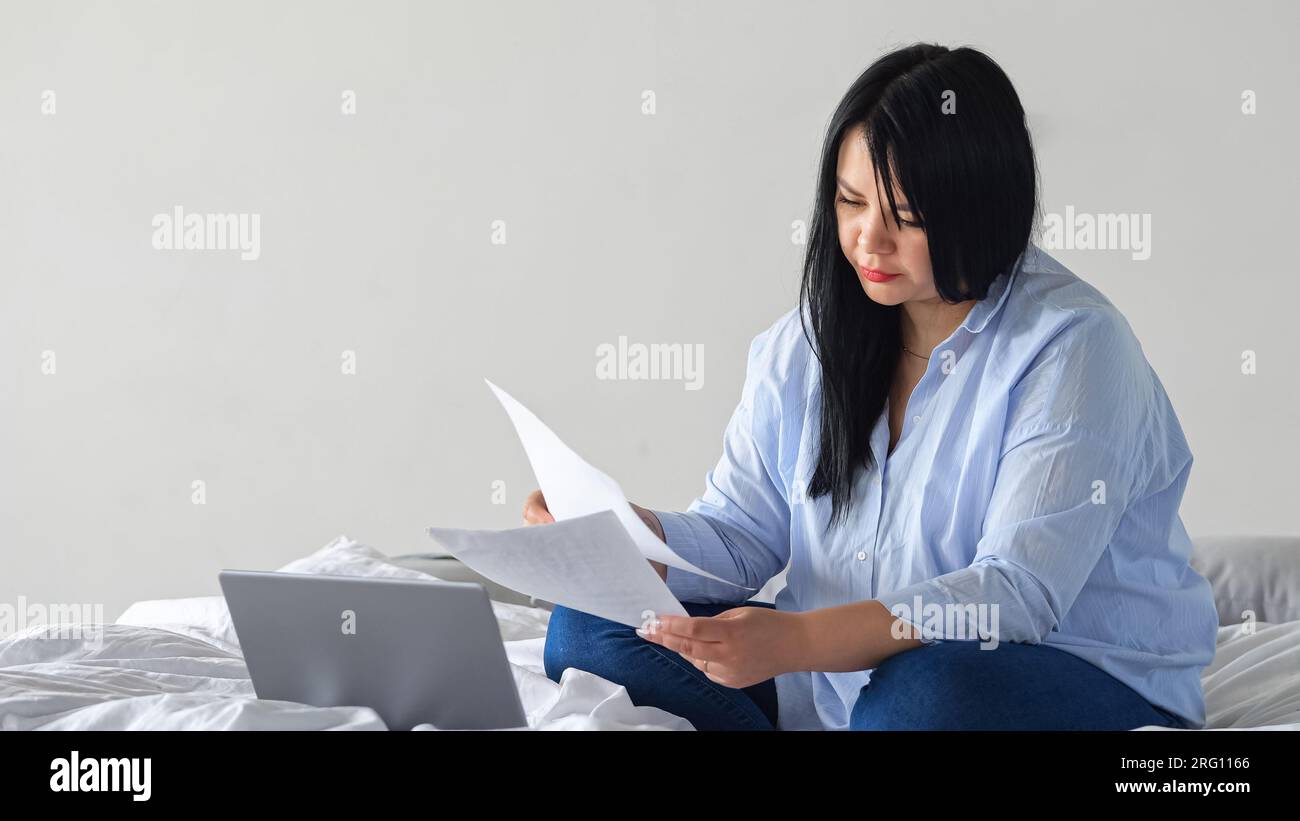 Black-haired lady receives positive letter from company Stock Photo - Alamy