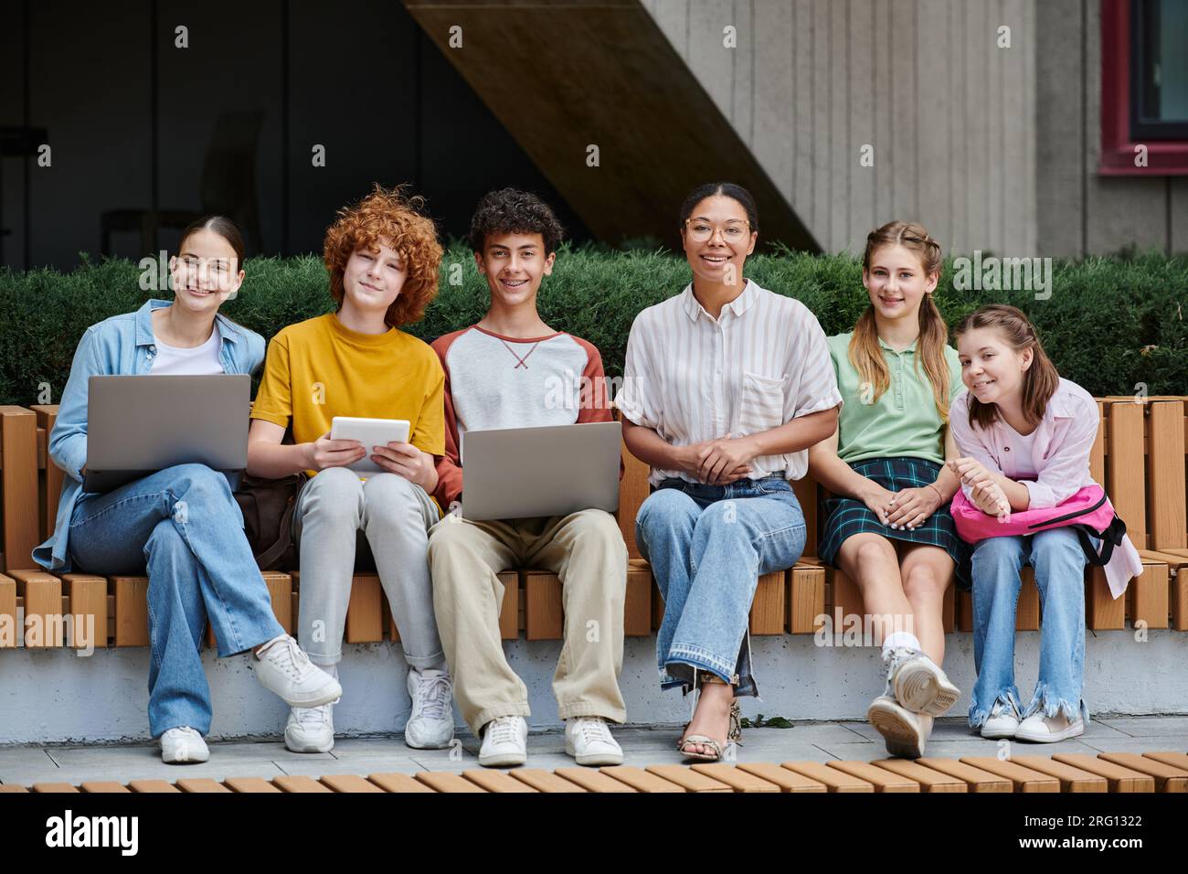 back to school, teenagers with gadgets sitting with african american ...