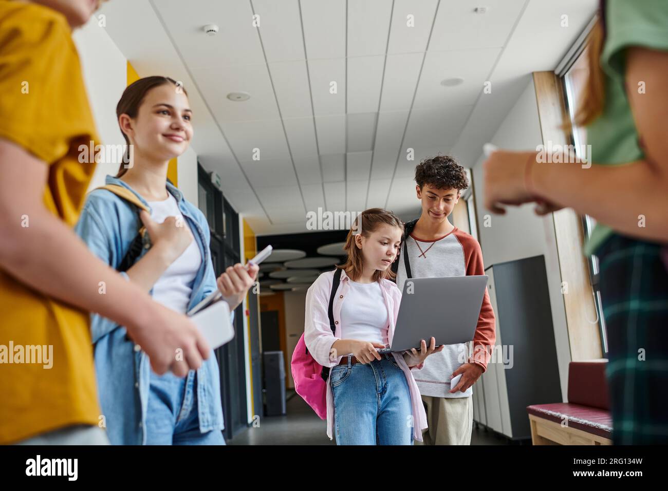 teenage girl and boy using laptop in school hallway, student life, teen ...