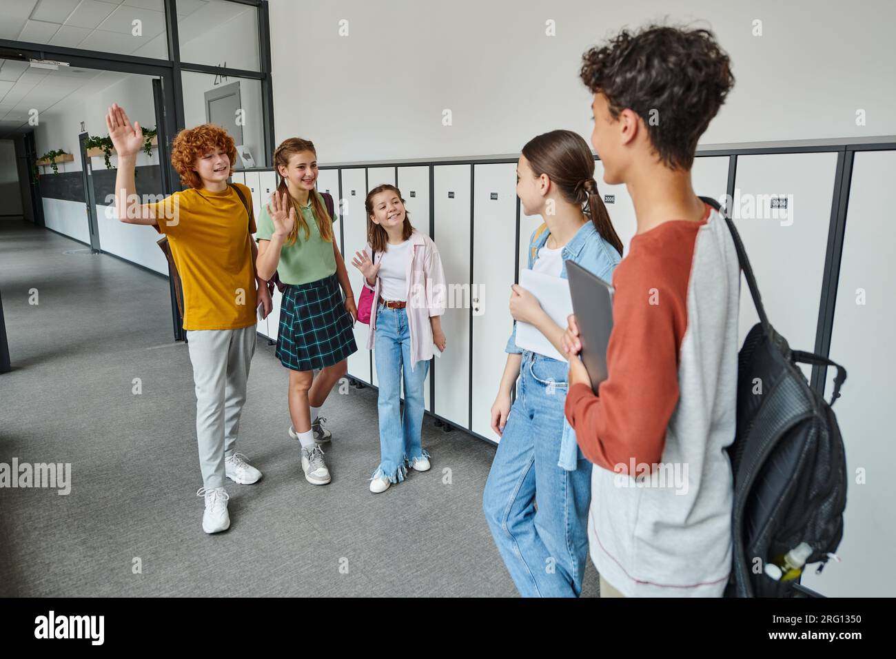 back to school, happy teen students waving hands and looking at ...