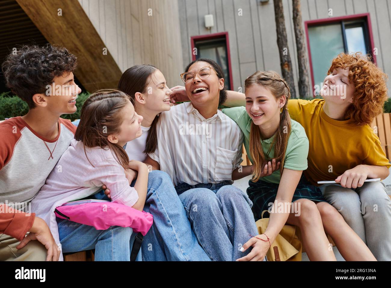 cheerful african american woman hugging with teenage students ...