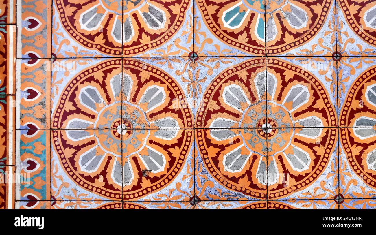 Ancient tiles floor texture with floral ornament of orange, blue and ...