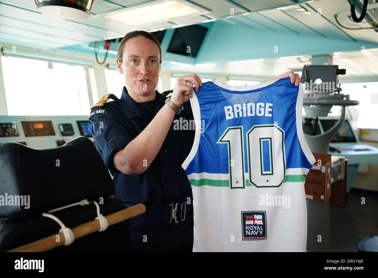 Commanding Officer Bridget MacNae shows her sports jersey to the media ...