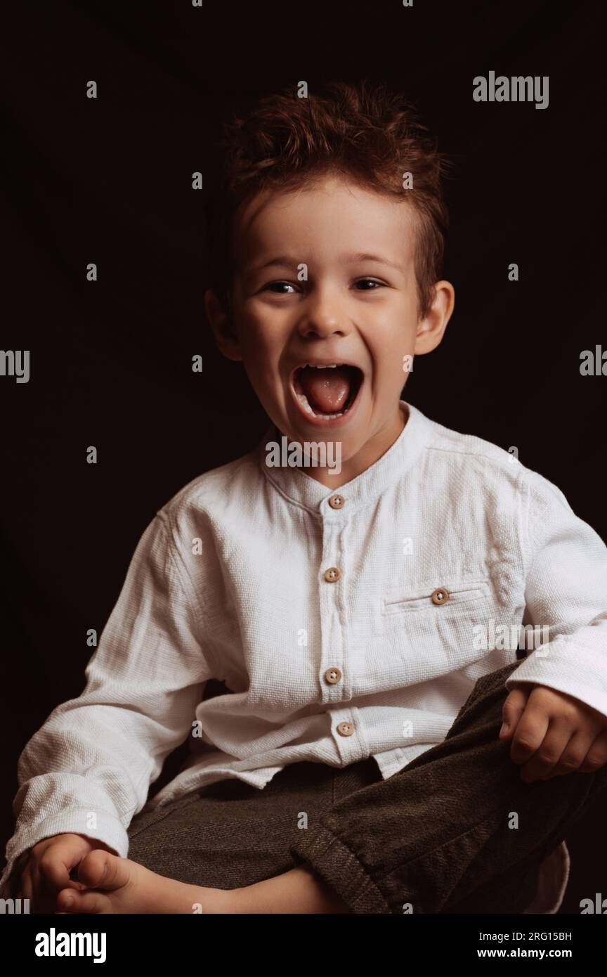 preschool child boy screams while sitting on a chair Stock Photo - Alamy