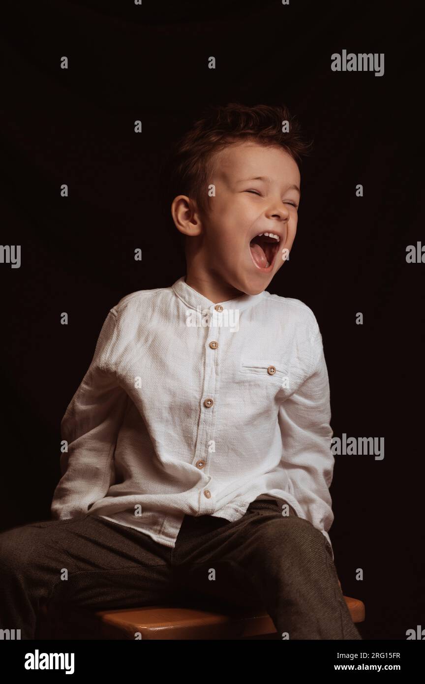 preschool child boy screams while sitting on a chair Stock Photo - Alamy