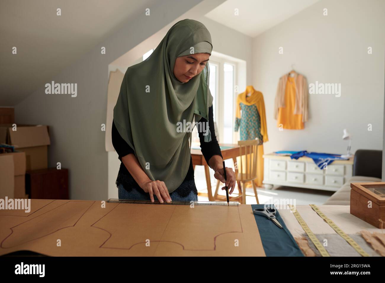 Tailor drawing sewing pattern of dress for client Stock Photo - Alamy