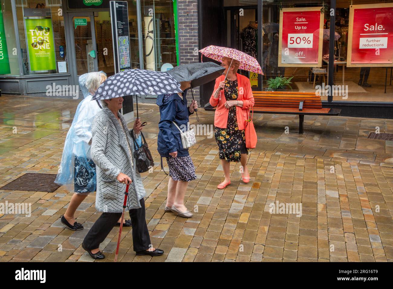 People walking and shopping in the rain, under umbrella's in the high ...