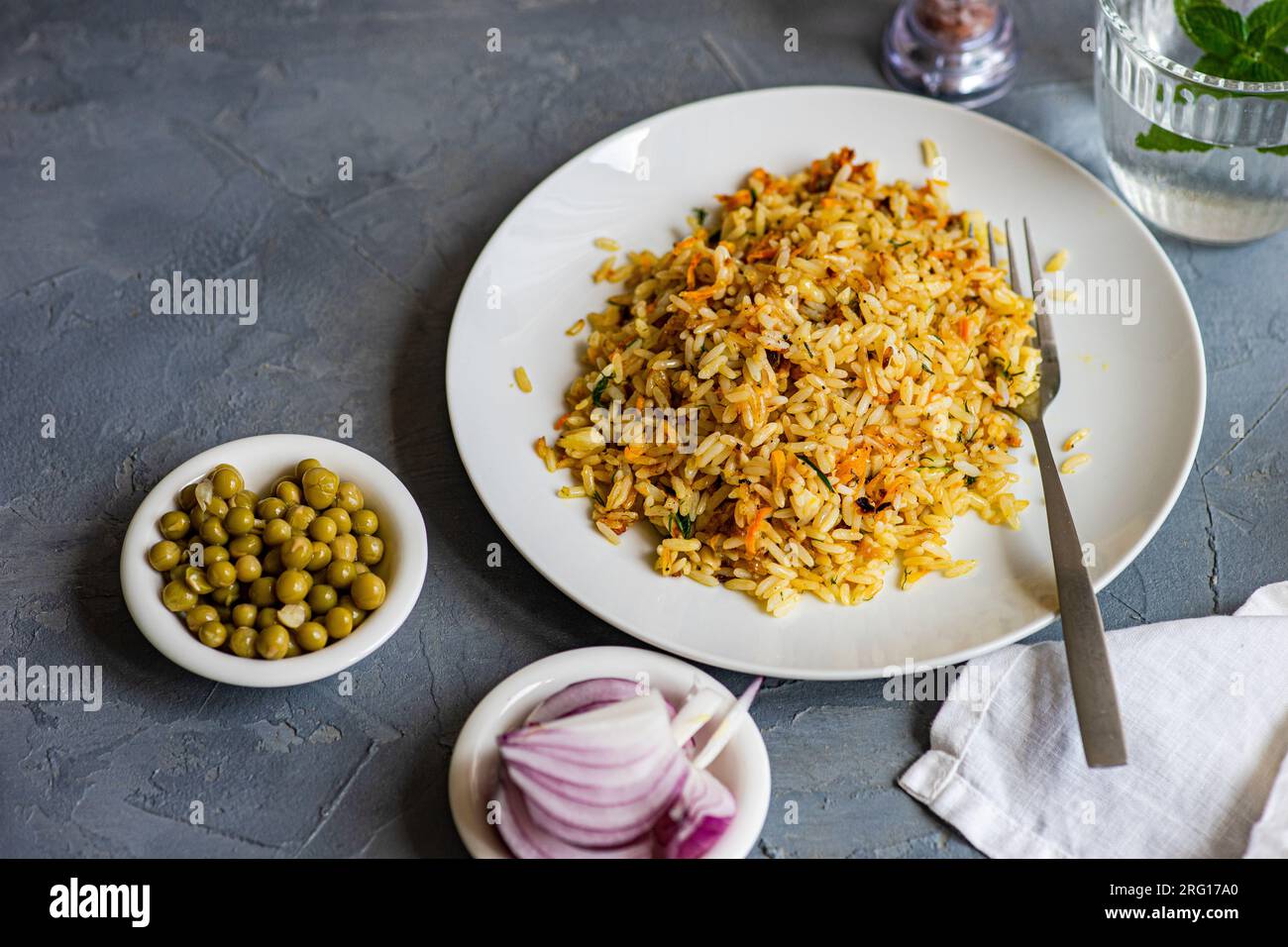 High angle of boiled rice with onion, carrot, bell pepper, green peas ...