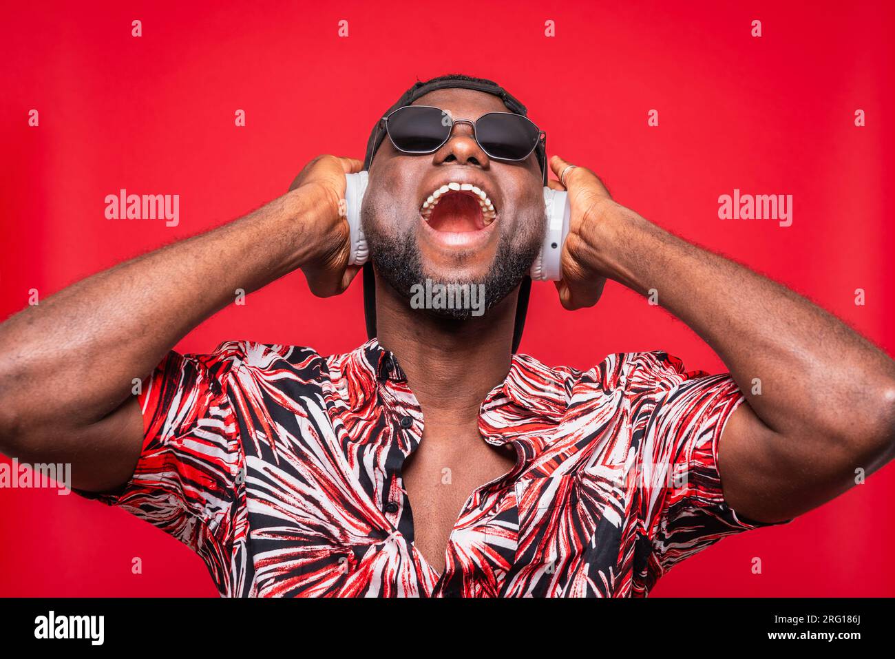 Portrait of happy and excited man in sunglasses with cap worn backward ...
