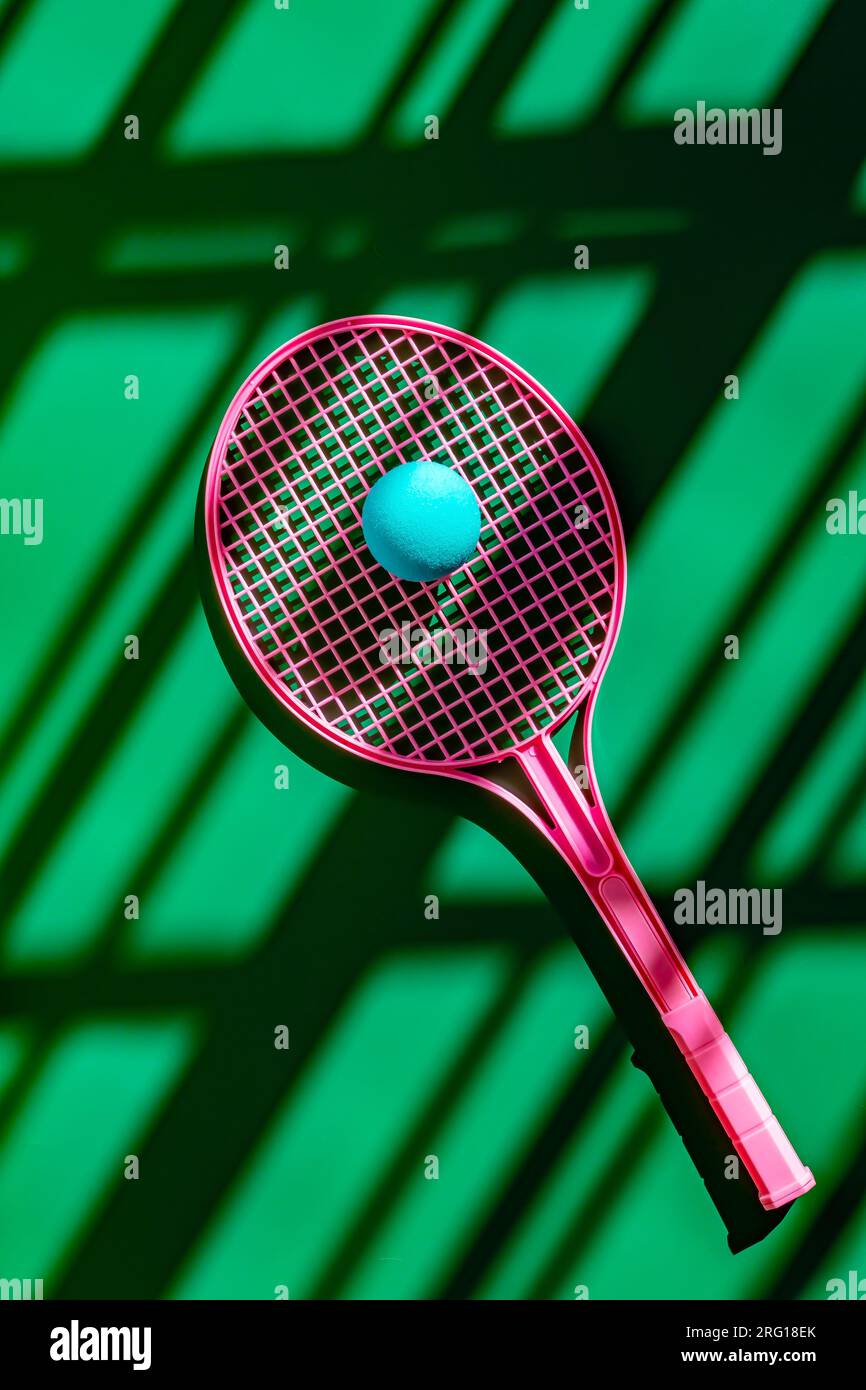 Top view of creative design of pink tennis racket and blue ball against ...
