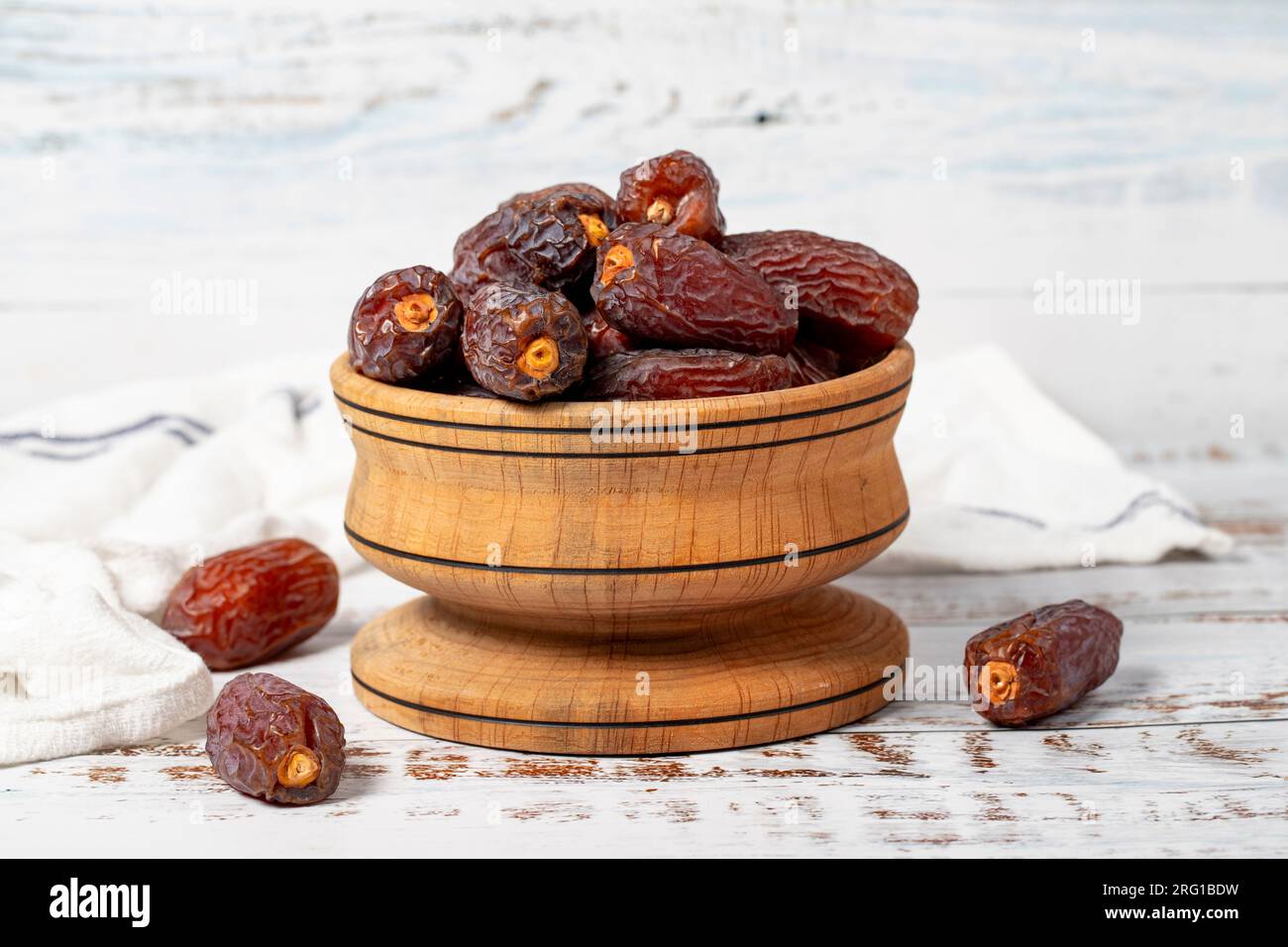 Date fruit in wood bowl. Natural dates on a white wood background Stock ...