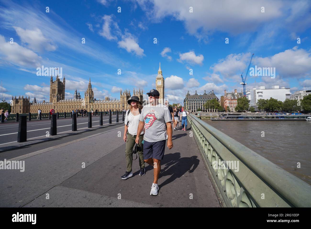 London UK. 7 August 2023 . Pedestrians walking in the bright sunshine ...