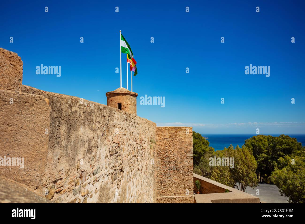 Flags on top of castle Gibralfaro fortress walls in Malaga Stock Photo ...