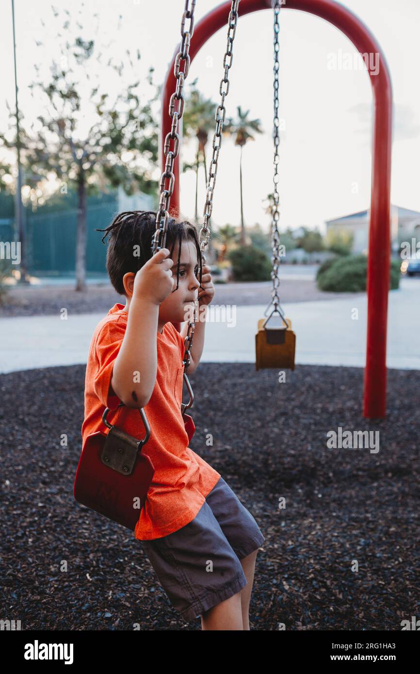 Small boy swinging Stock Photo - Alamy