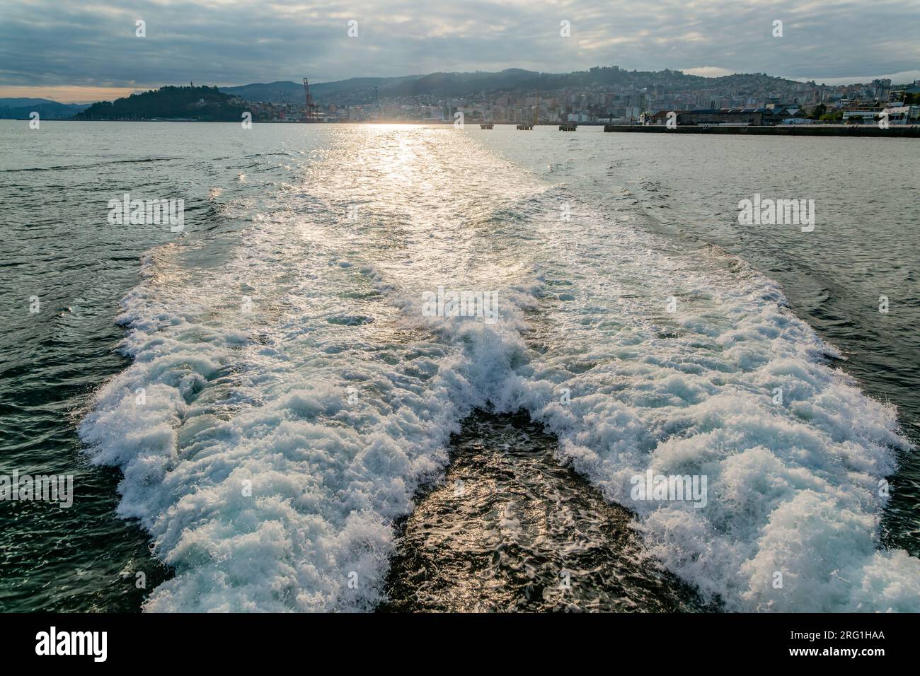 Bright sunbeam haze illuminating waves of ferry boat ship's wake, Vigo ...