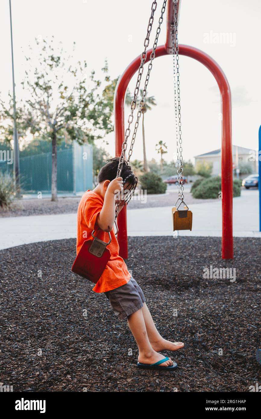 Little boy swinging Stock Photo - Alamy