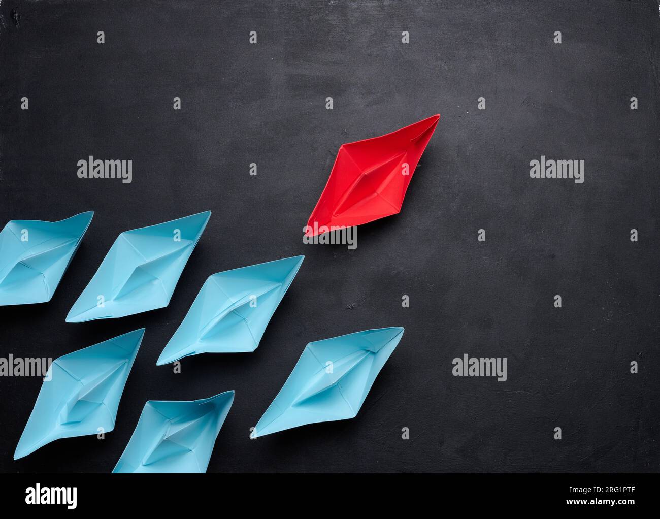 Group of paper boats on a black background.Concept of a strong leader ...