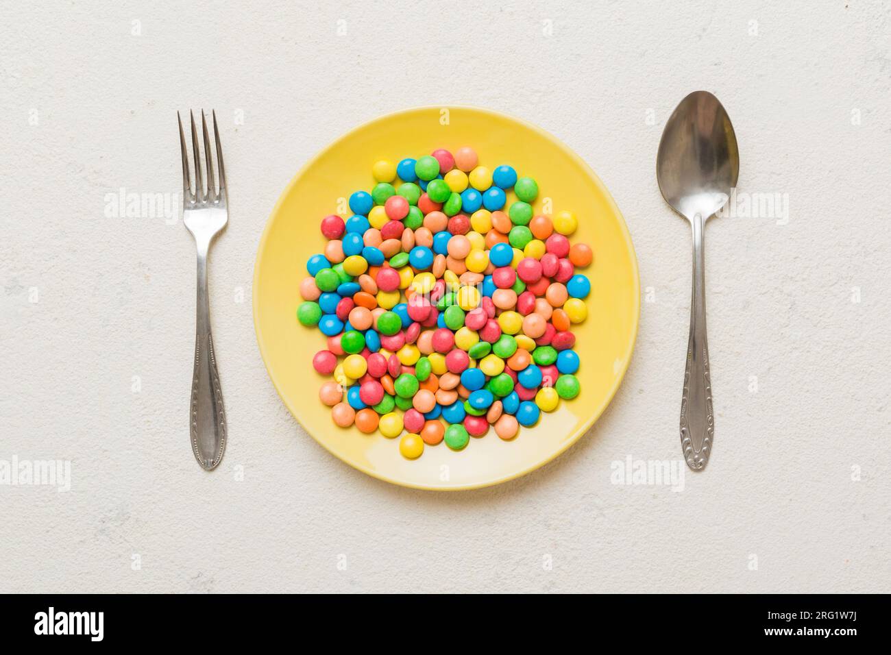 cutlery on table and sweet plate of candy. Health and obesity concept ...