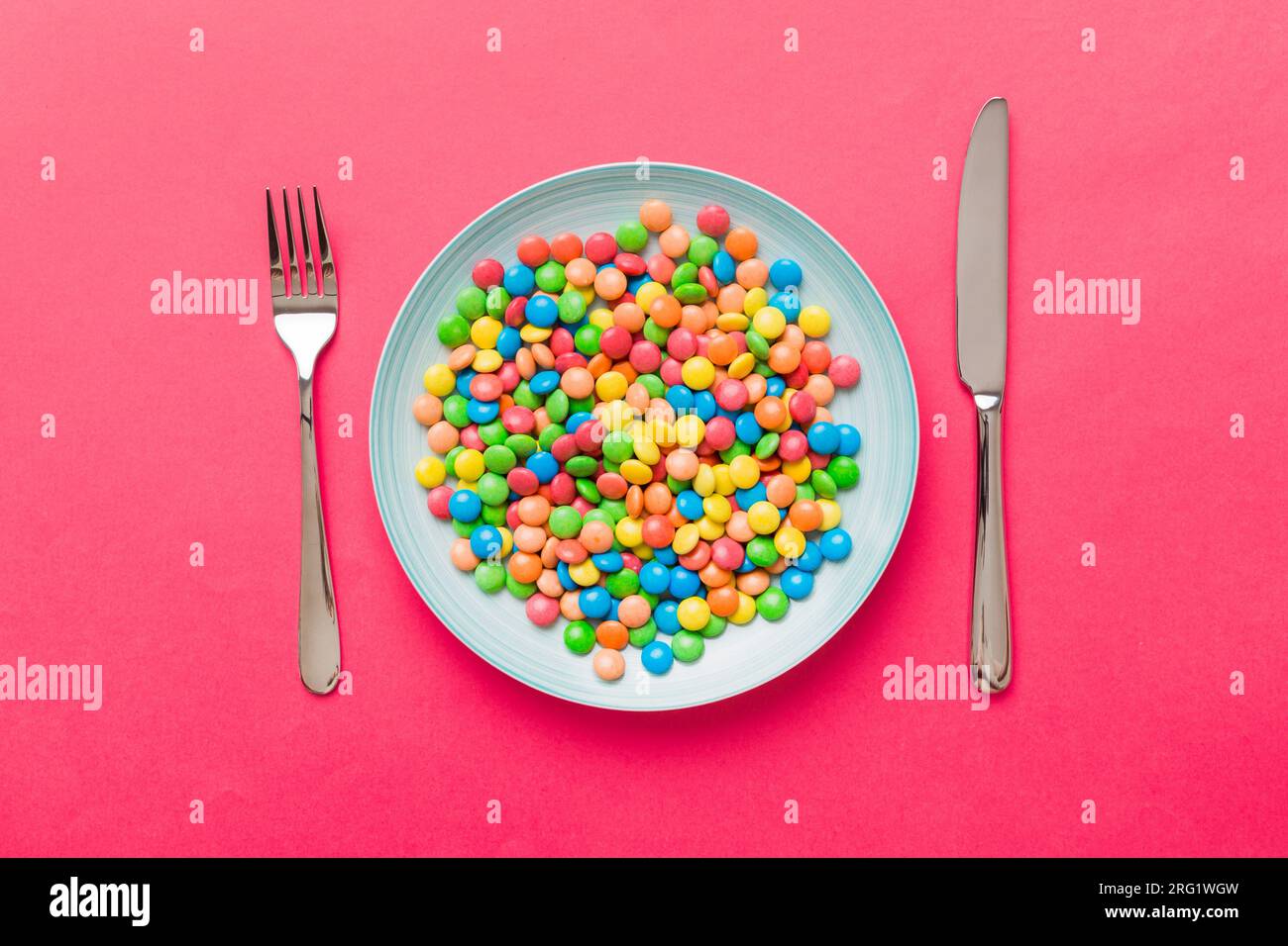 cutlery on table and sweet plate of candy. Health and obesity concept ...