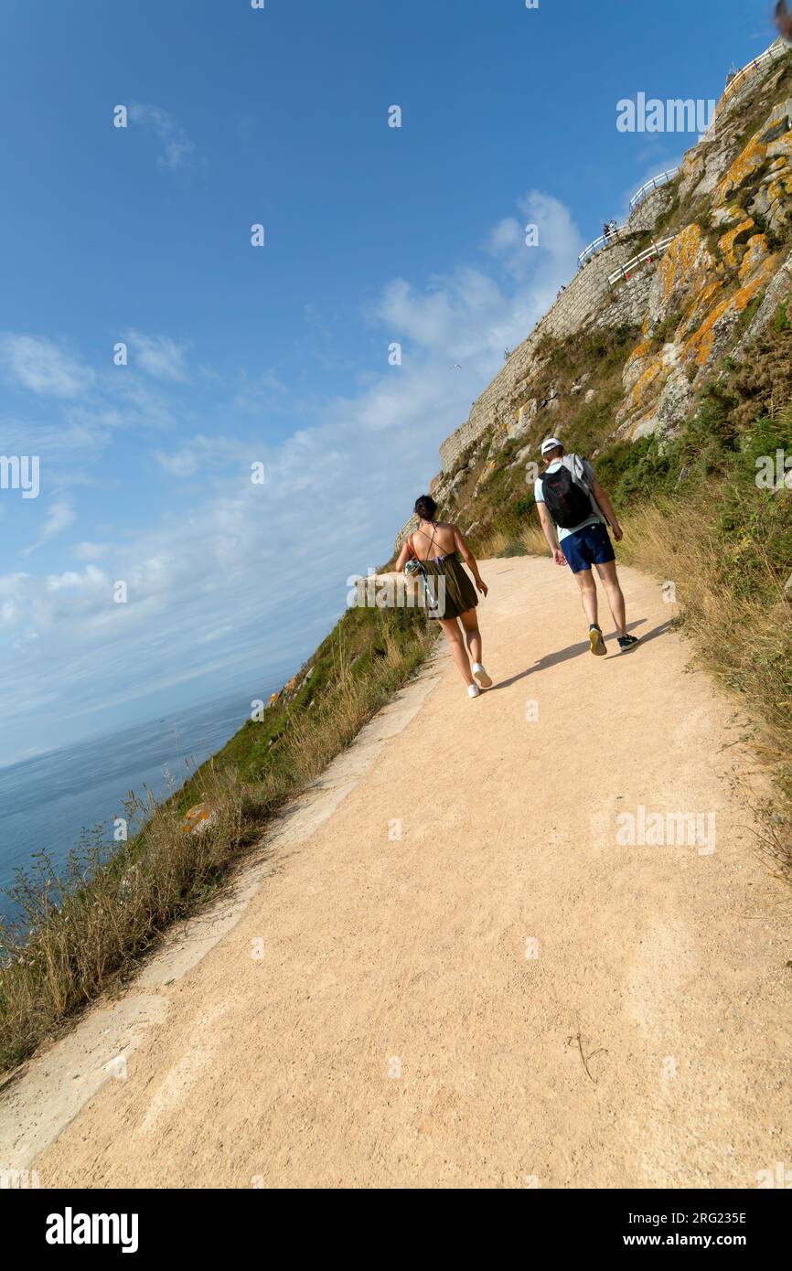 Hikers on steep pathway to Cies Island lighthouse, Atlantic Islands ...