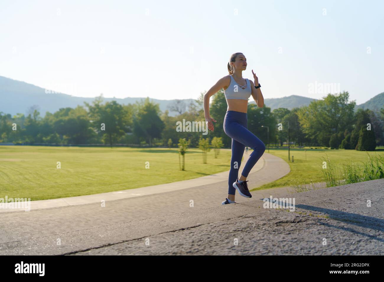 Sporty woman running on the concrete stairs in city park Stock Photo ...