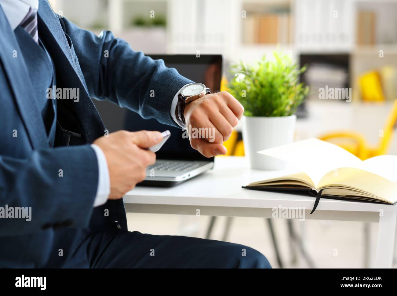 Man in suit and tie check out time at silver wristwatch Stock Photo - Alamy