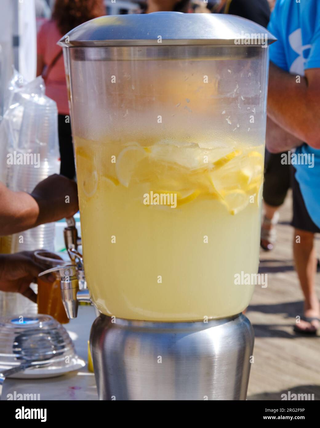 Large lemonade jar dispenser with real lemon slices outdoors at a food ...