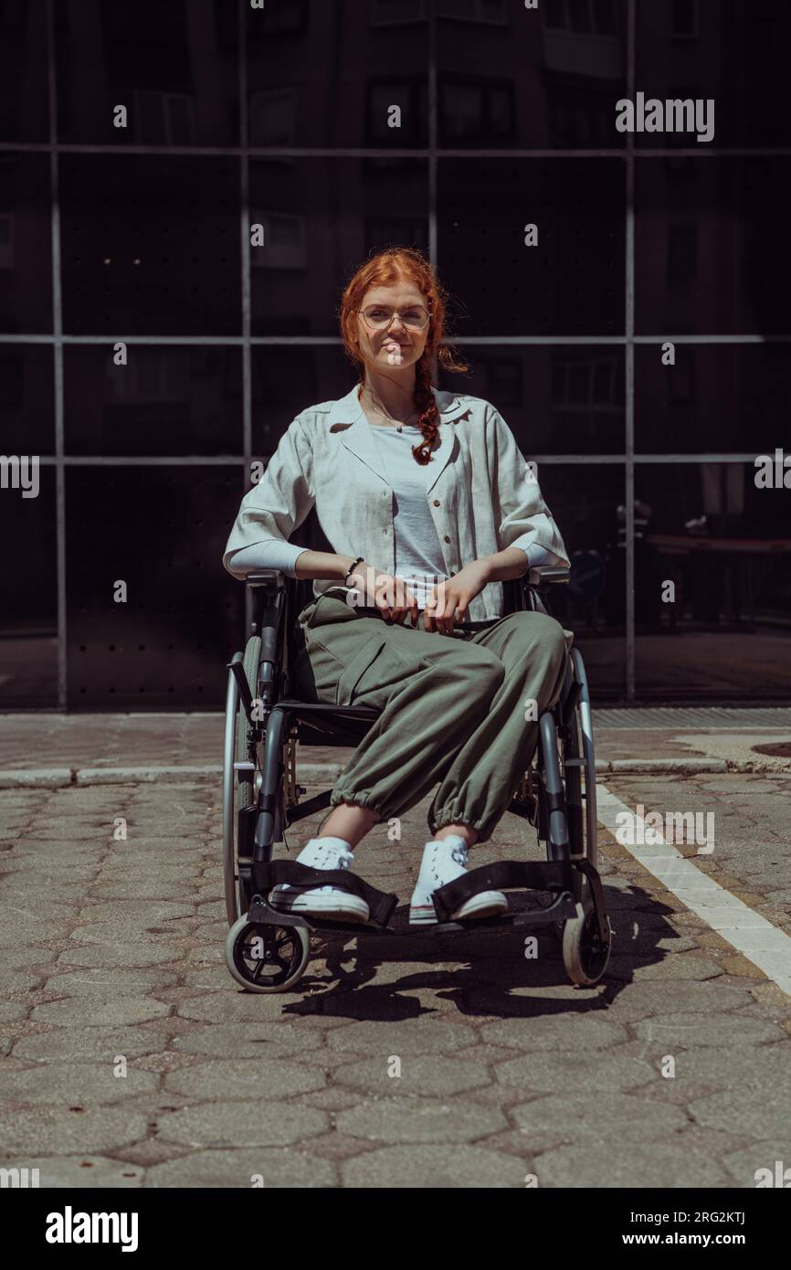 In front of a modern corporate building, a young woman sitting in a ...