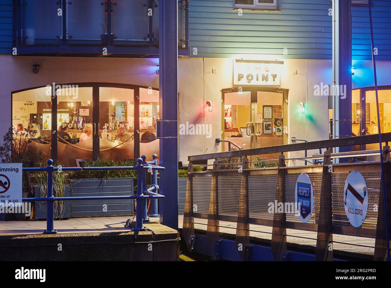 A harbourside cafe and apartment building beside a lifting bridge, seen ...