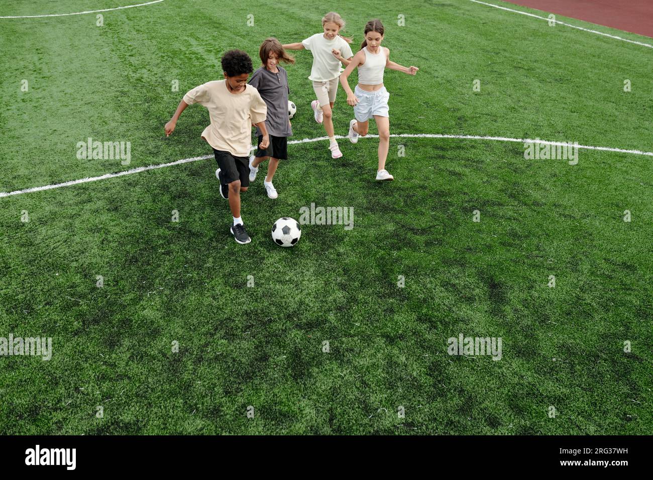 Team of four intercultural friends or classmates in activewear running ...