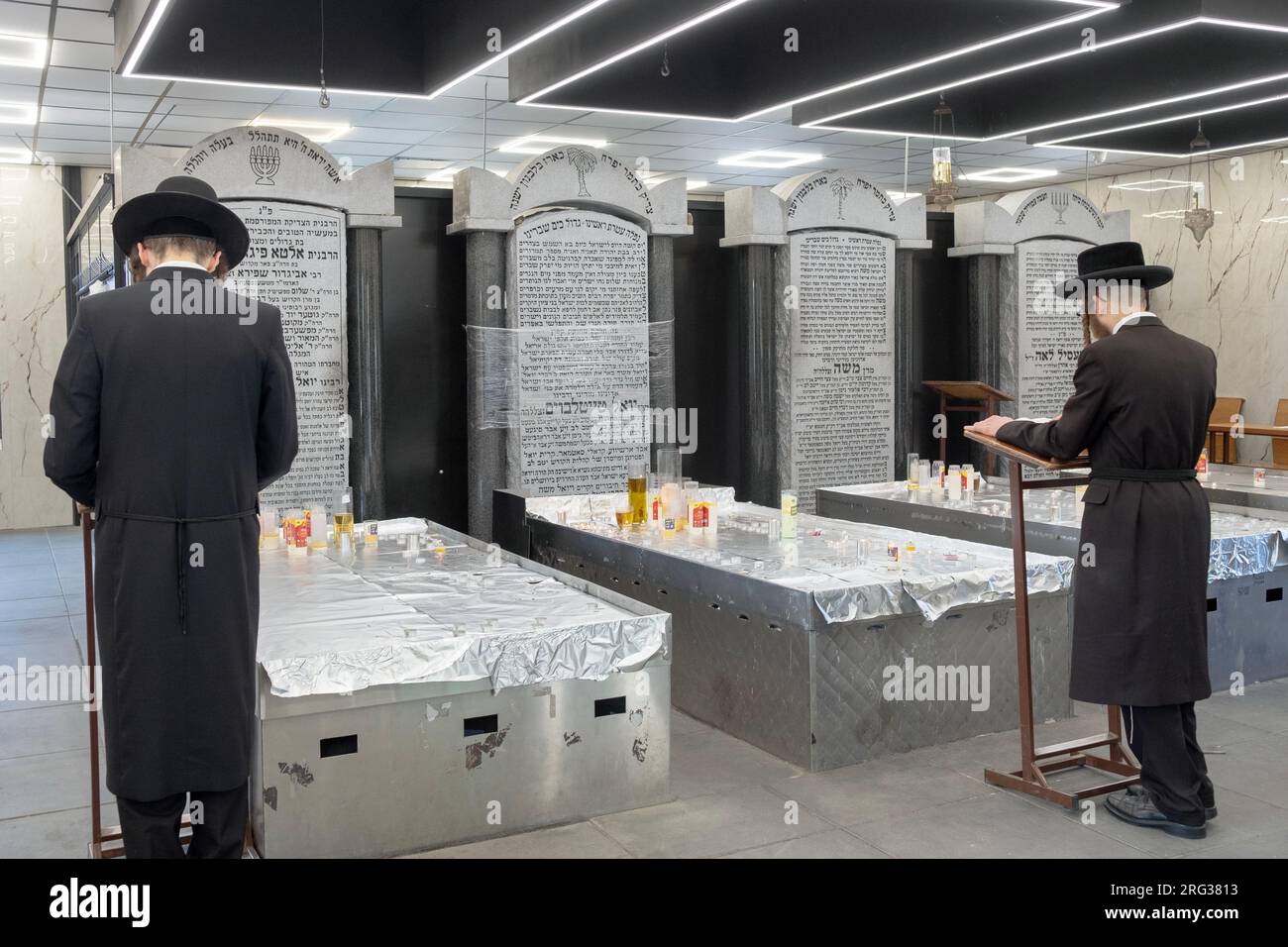 Orthodox Jewish men recite psalms at the headstone of Rabbis Yoel ...