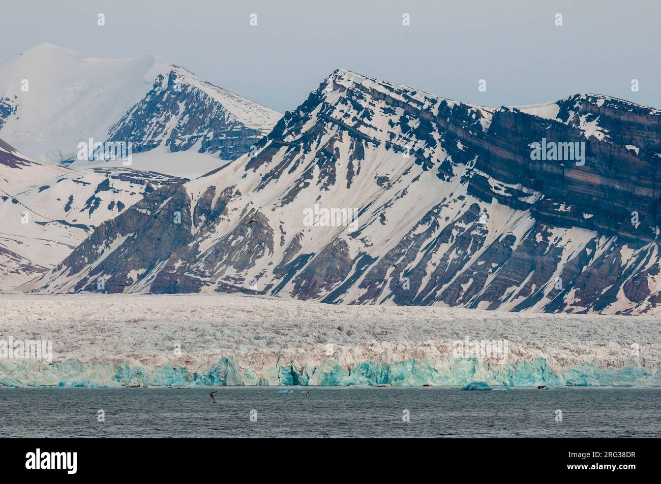 Ice capped mountains and a glacier border Kongsfjorden near Ny-Alesund ...