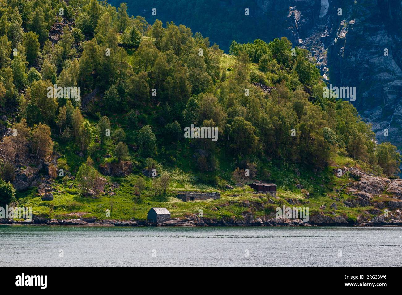 Primitive farm buildings built into the steep rugged mountains above ...