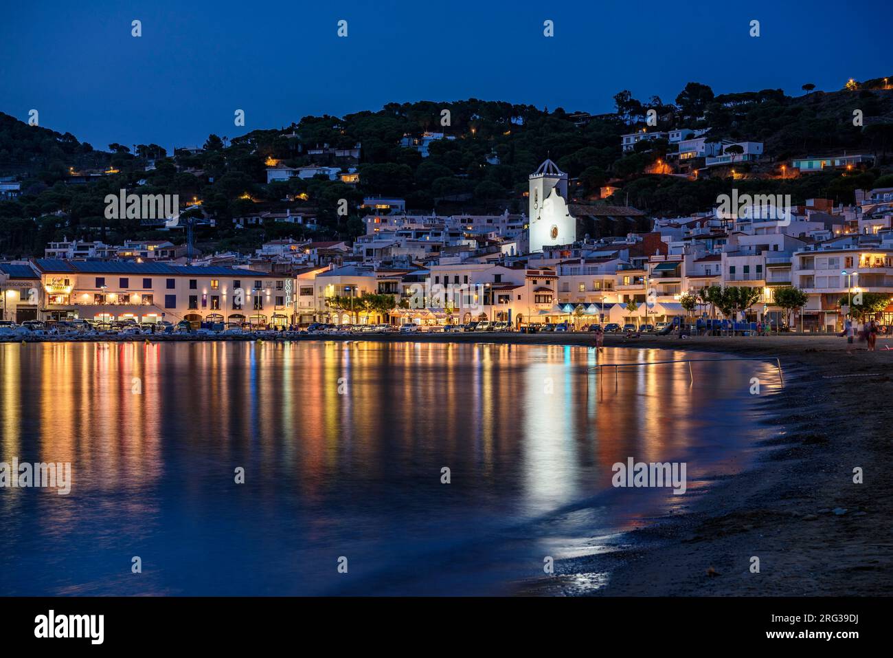 Harbor and beach of Port de la Selva, illuminated at night in the blue ...