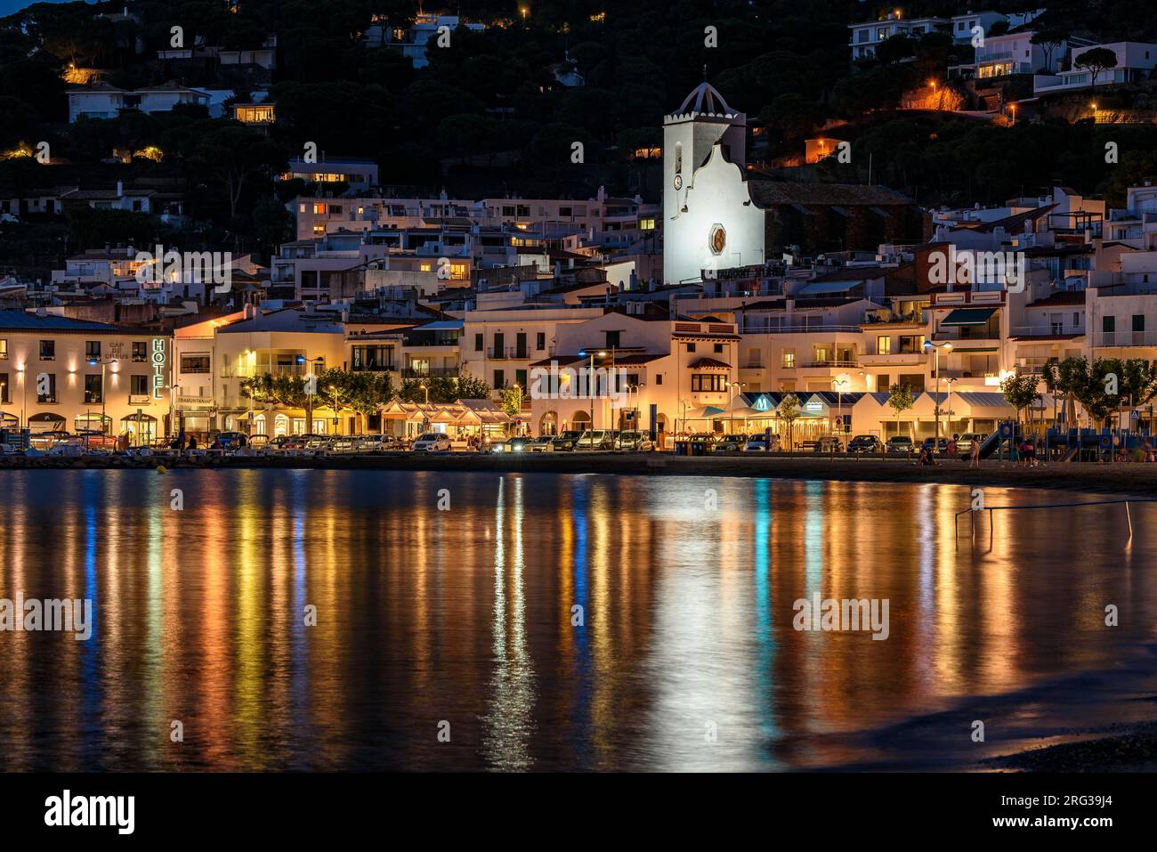 Harbor and beach of Port de la Selva, illuminated at night in the blue ...