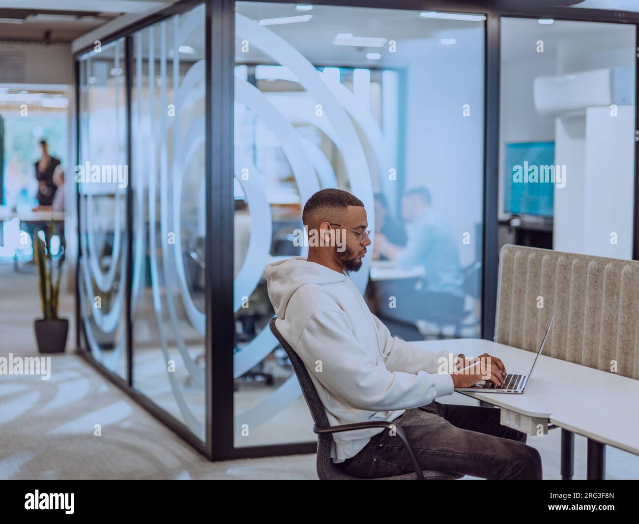 In a modern office setting, an African American businessman is ...