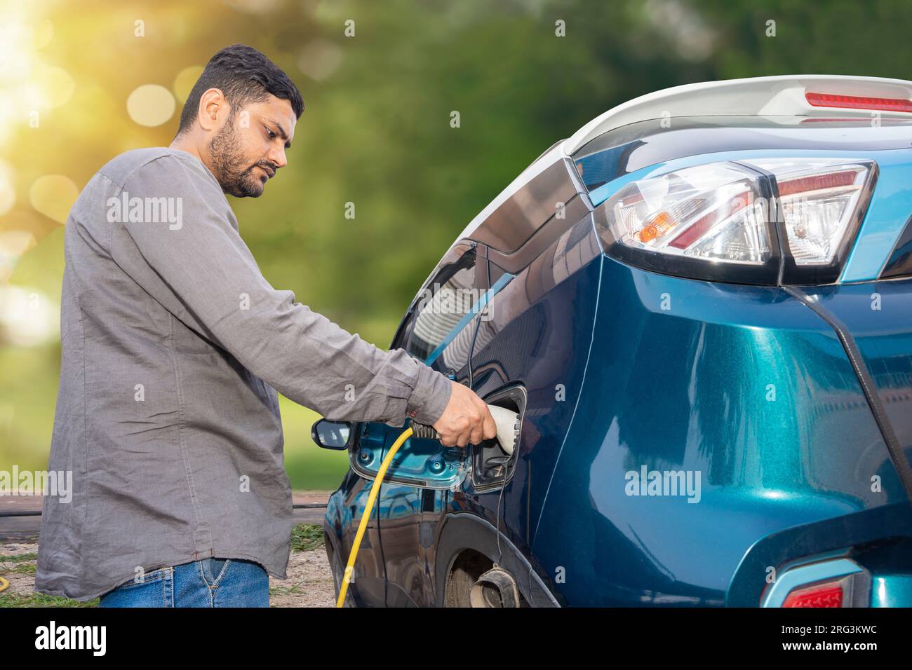 Indian man attaching power cable into socket to charge his modern ...