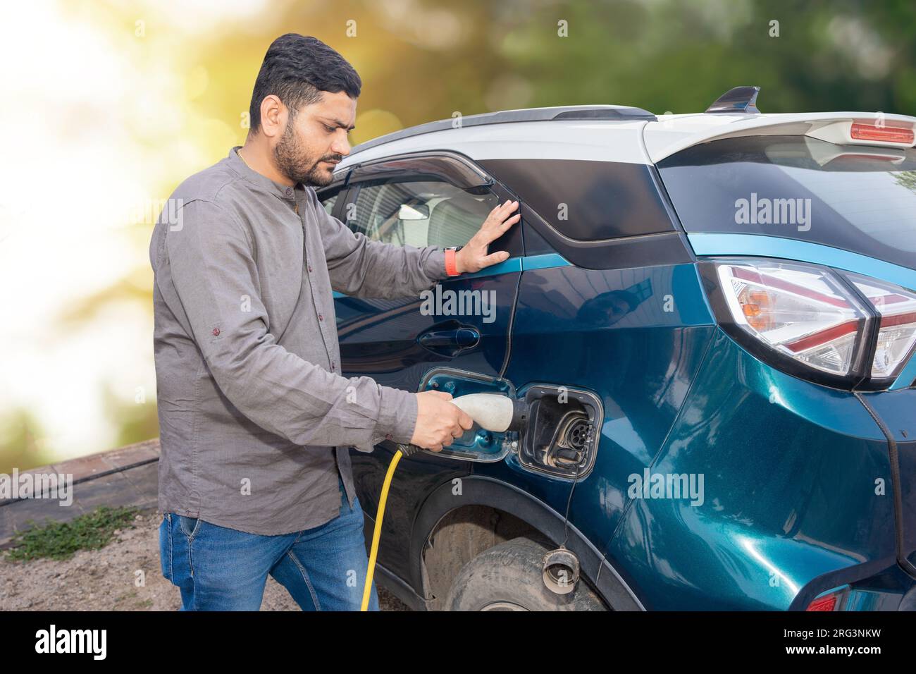 Indian man attaching power cable into socket to charge his modern ...