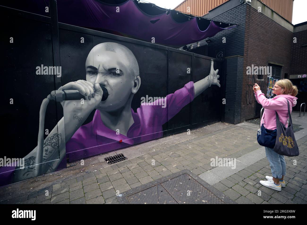 A person taking a photo of a mural of Sinead O'Connor by Artist ...