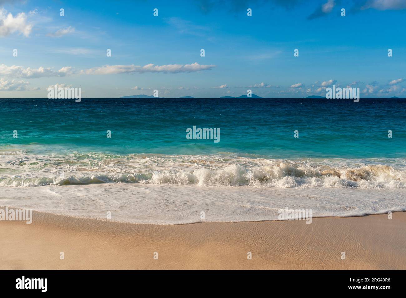 Indian Ocean surf surging onto a sandy tropical beach. Anse Macquereau ...
