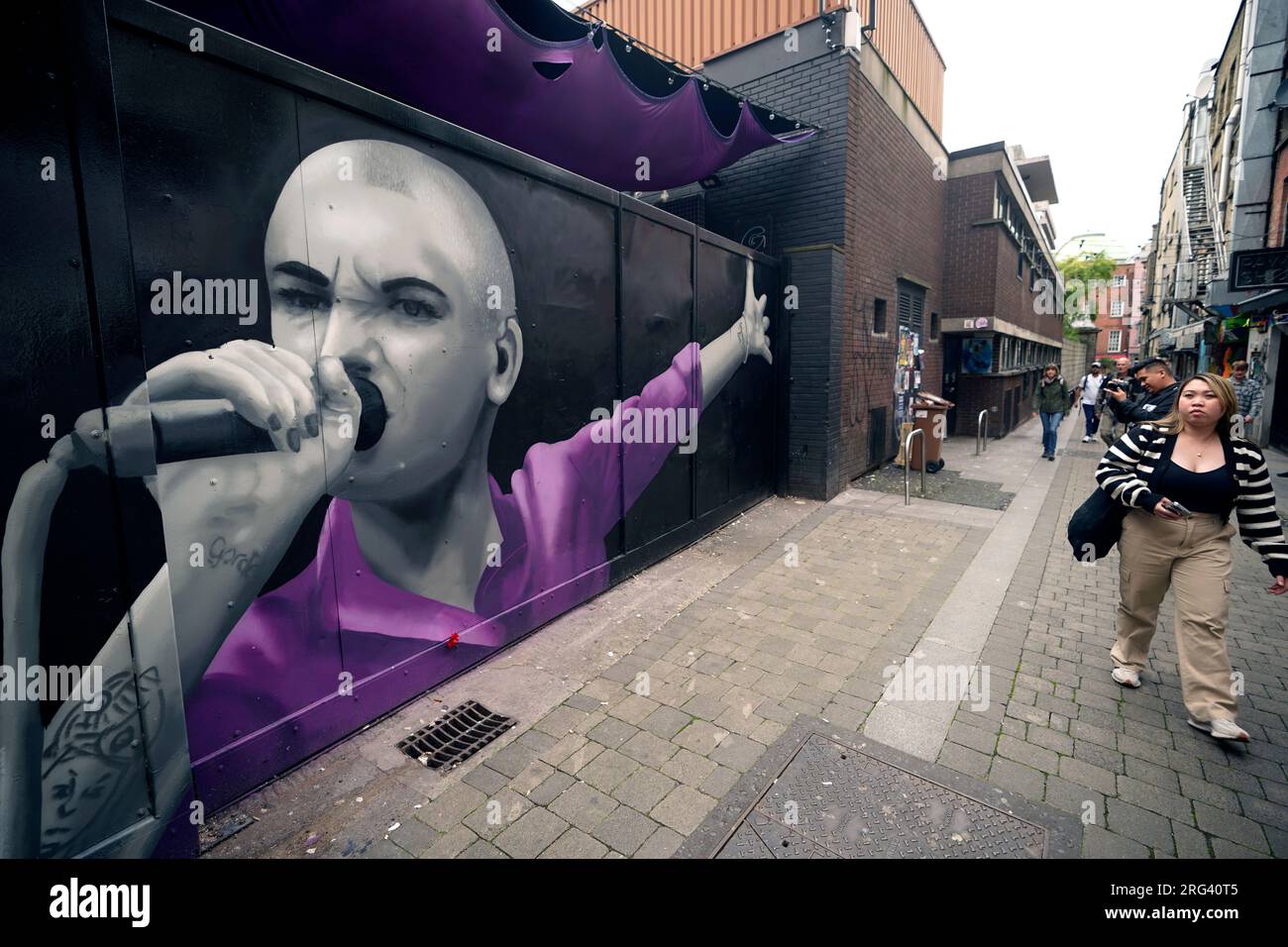 People walking past a mural of Sinead O'Connor by Artist, Emmalene ...