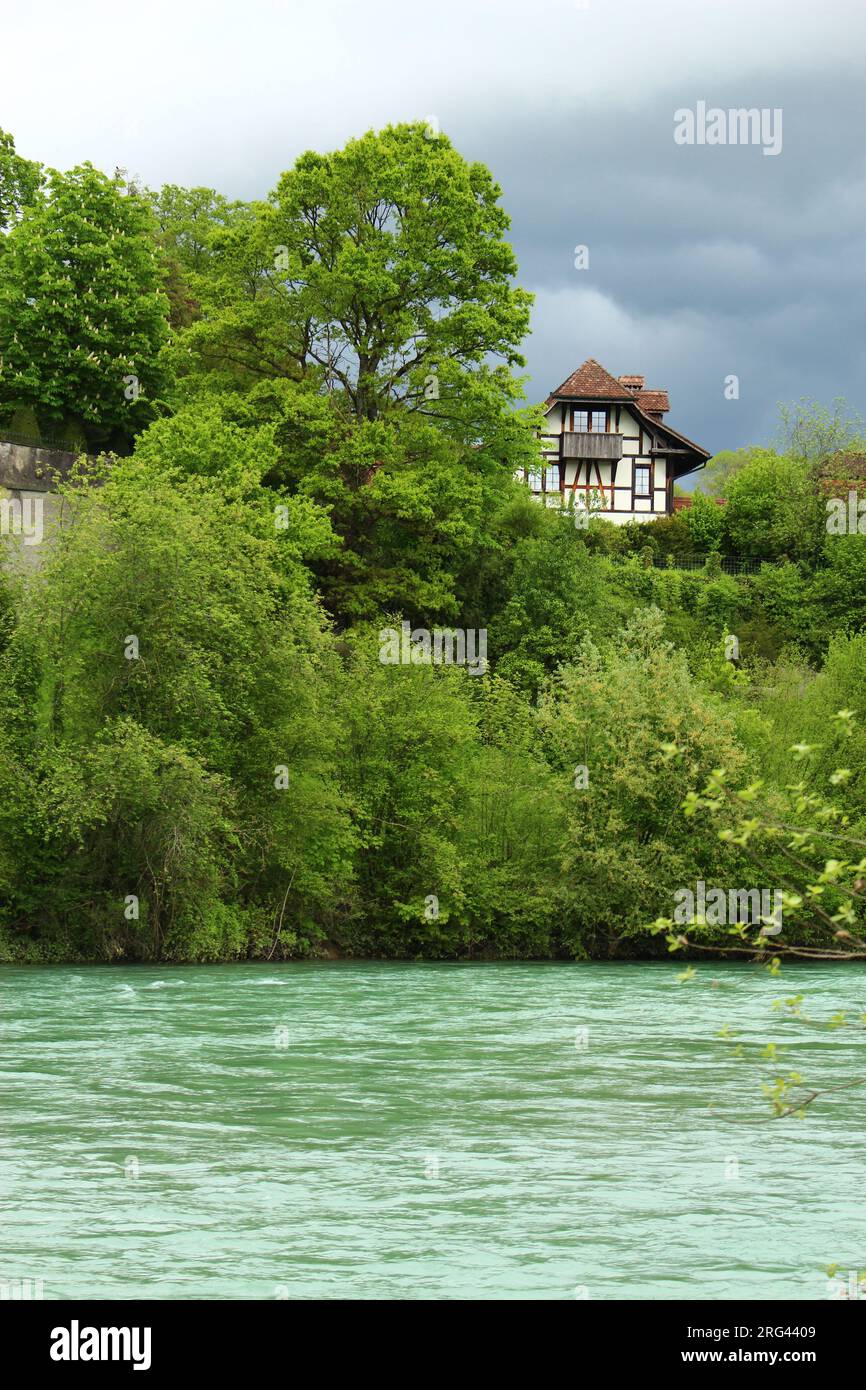 Typical Swiss Cottage on a hill above the River Aare on an overcast day ...