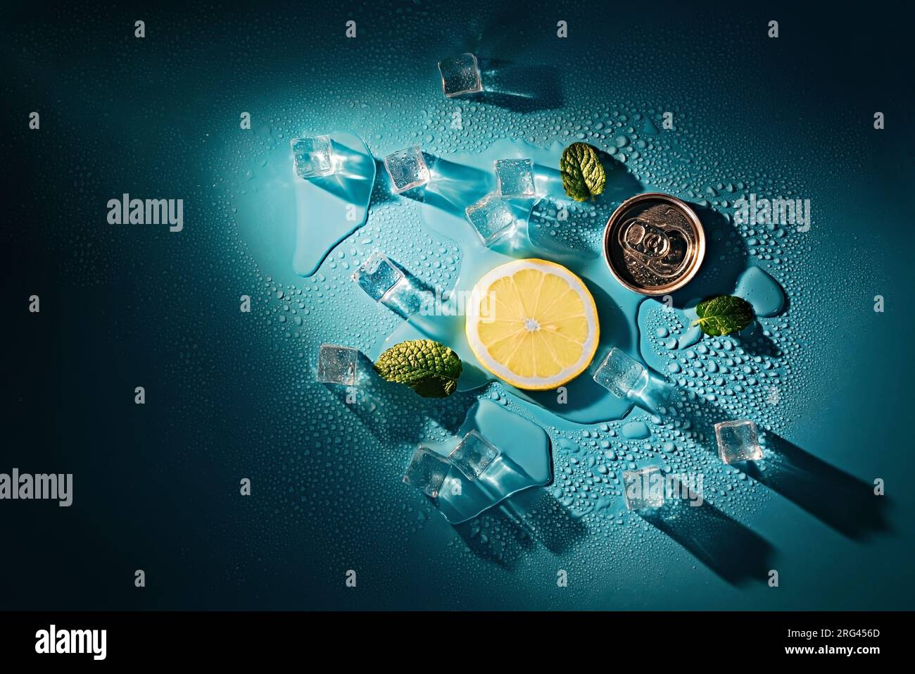 Creative summer composition with lemon slice, mint leaves, can of soda and ice cubes. Top down ...