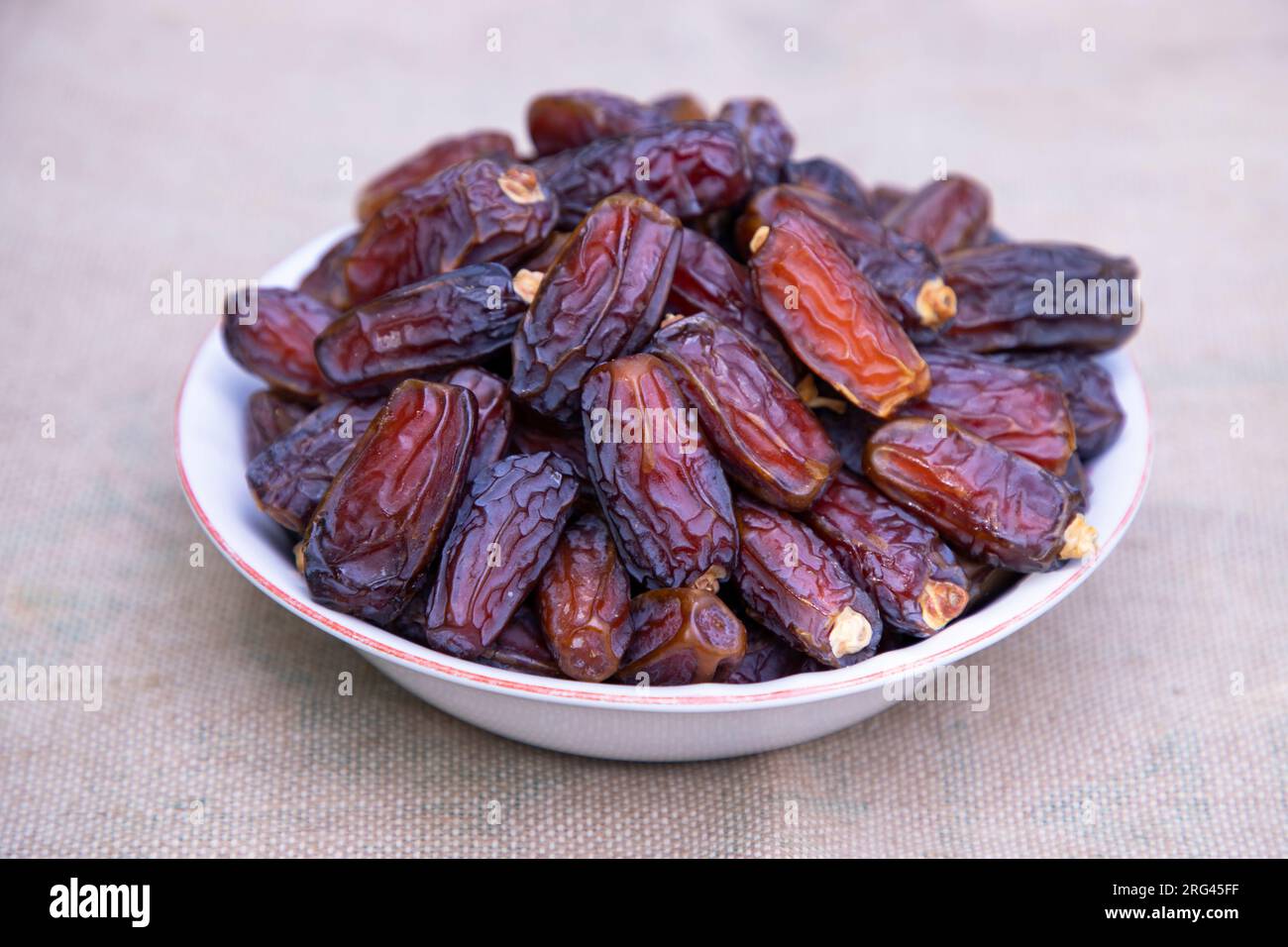 One bowl of delicious Date fruits on the jute fiber fabric Stock Photo ...